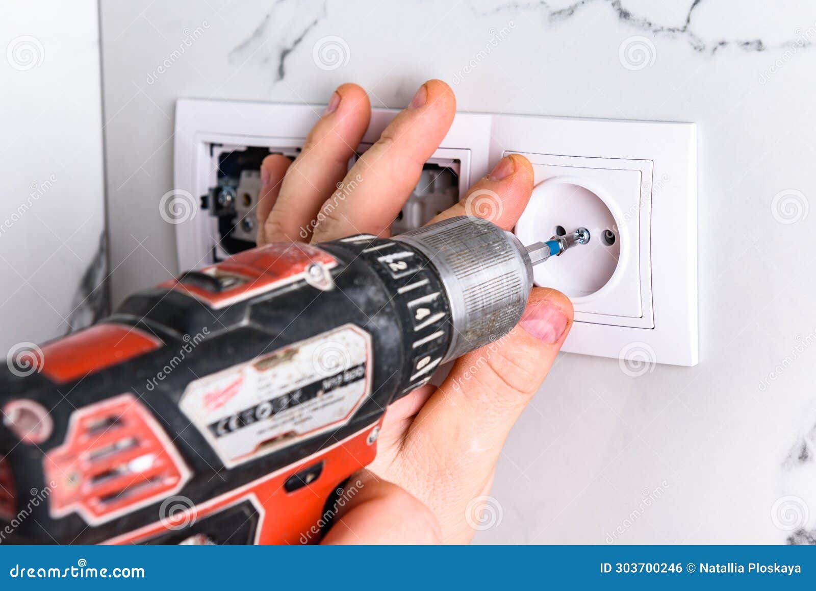 Installing Outlet on White Tile Wall Using Electric Screwdriver. Stock ...