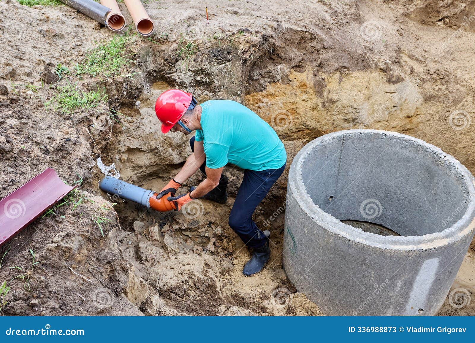 Plumber Inserts Bent Fitting into Socket of an Underground Sewer Inlet ...