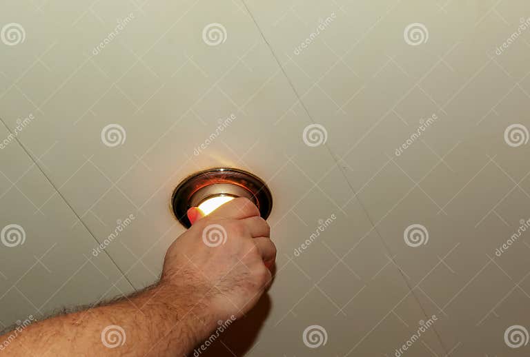 Installing a Spot Light, the Hand Inserts the Lamp into the Ceiling ...