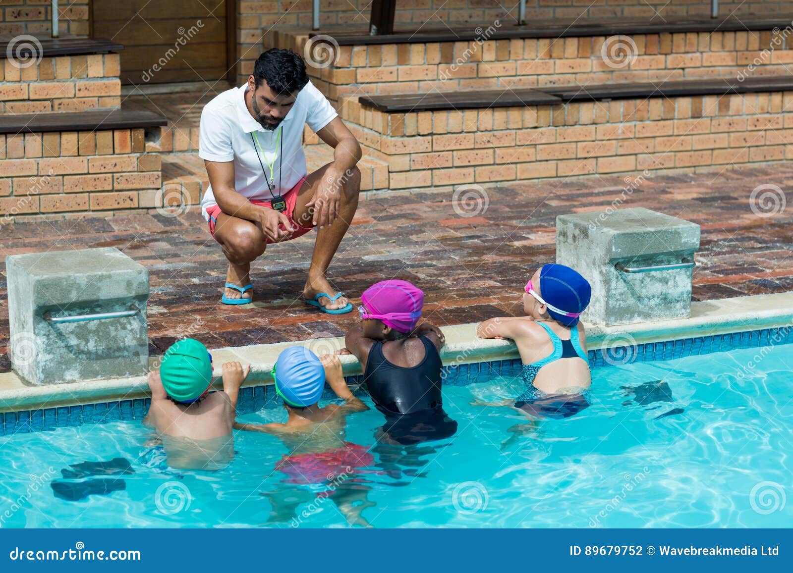 Instructor Advising Little Swimmers at Poolside Stock Photo - Image of ...