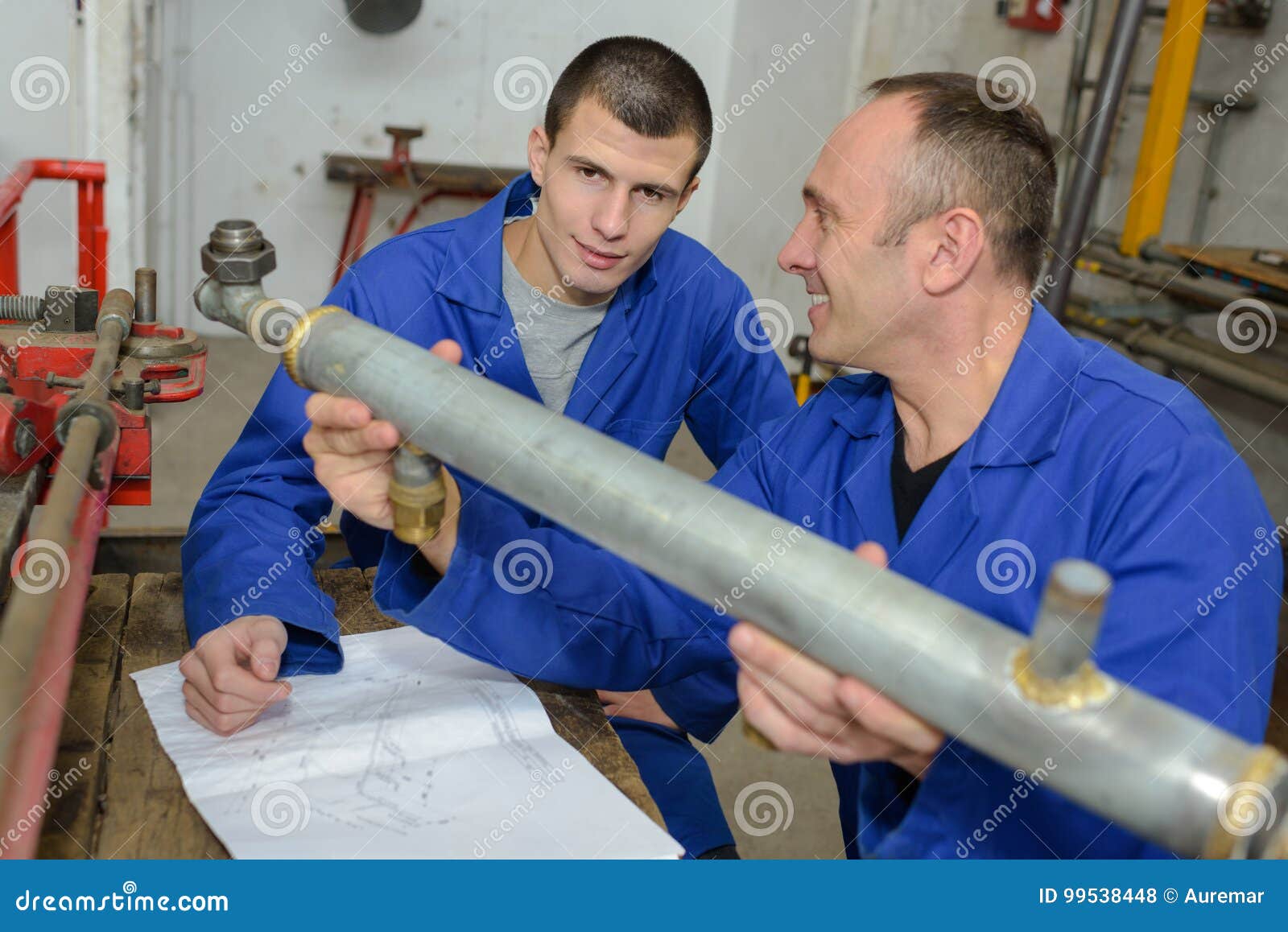 Instructor and Apprentice Looking at Pipe Stock Photo - Image of ...