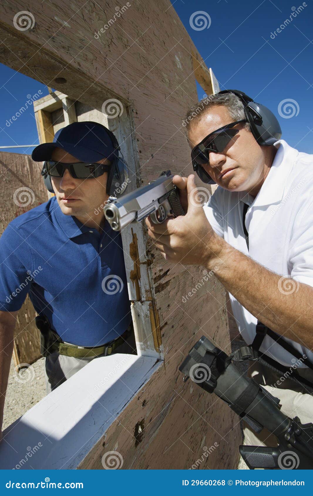 Instructor Assisting Man with Hand Gun Stock Photo - Image of machine ...