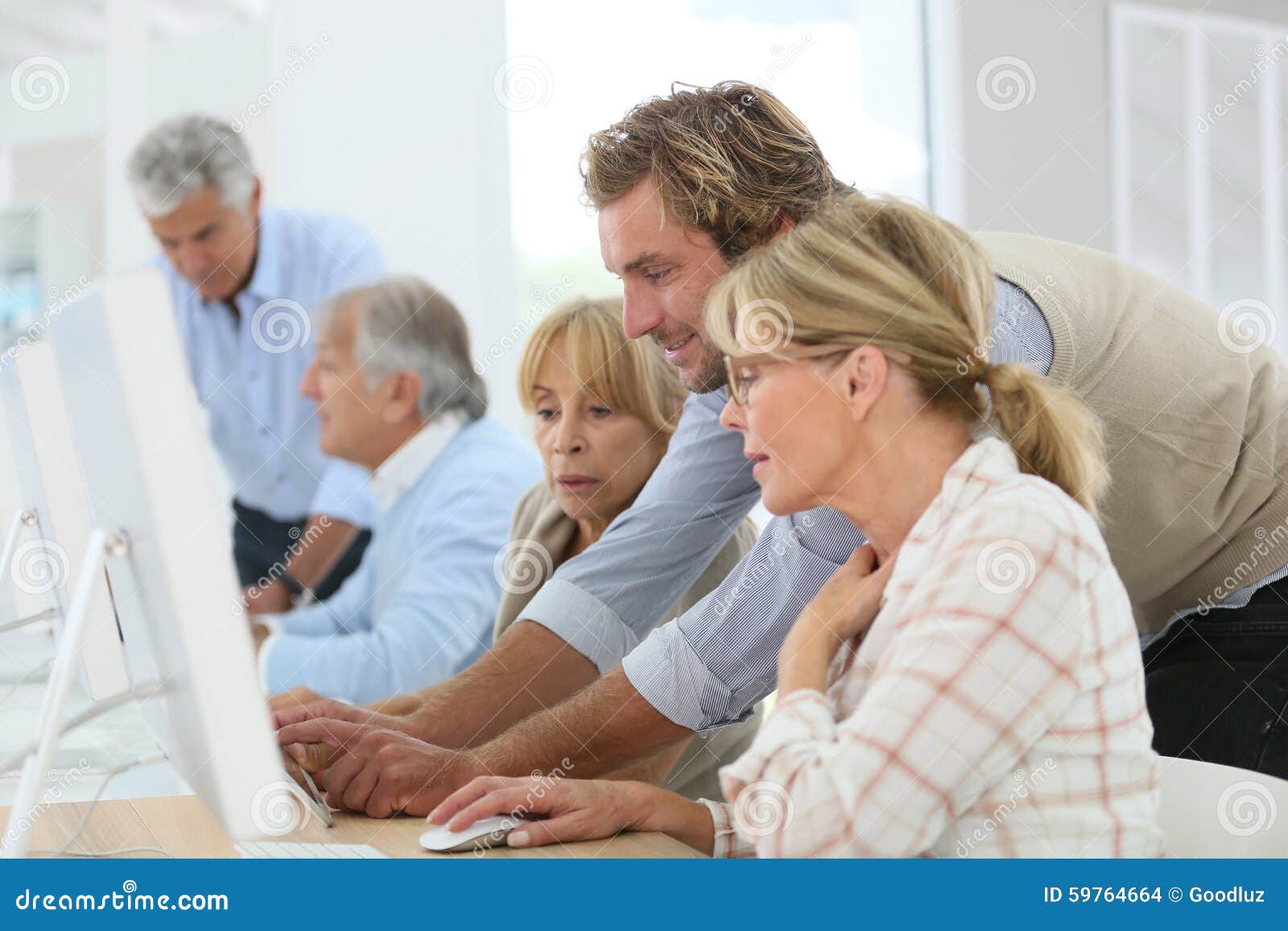 Instructor Assisting Seniors in Informatics Class Stock Photo - Image ...