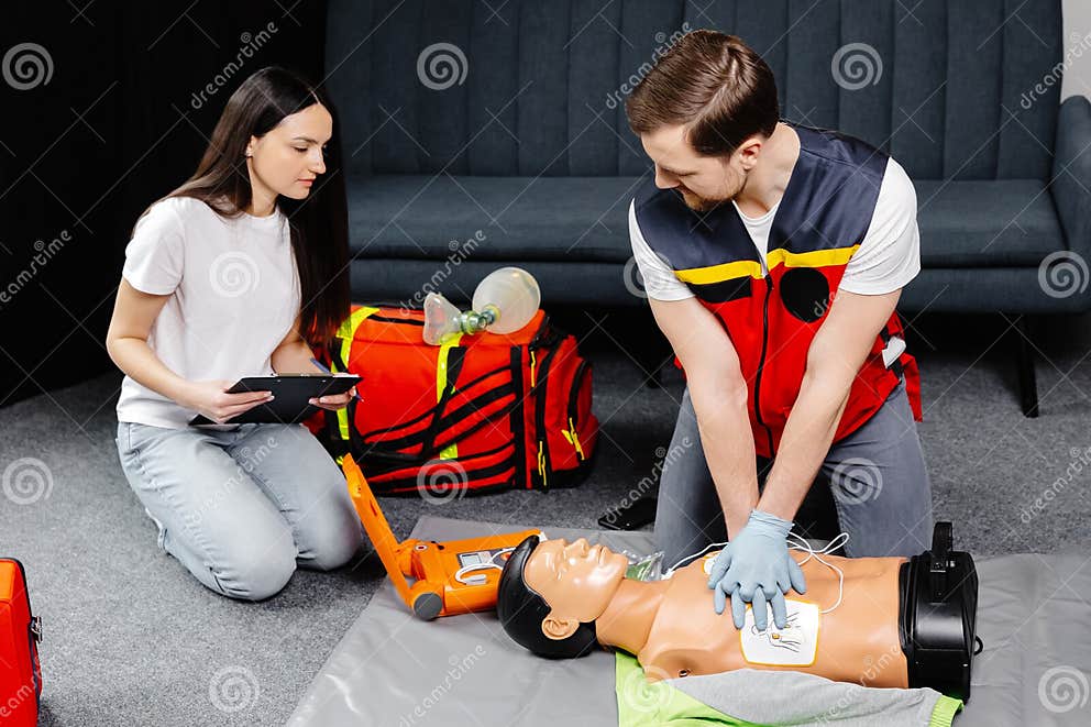 Instructor Demonstrating Cpr Chest Compression on a Dummy in Class ...