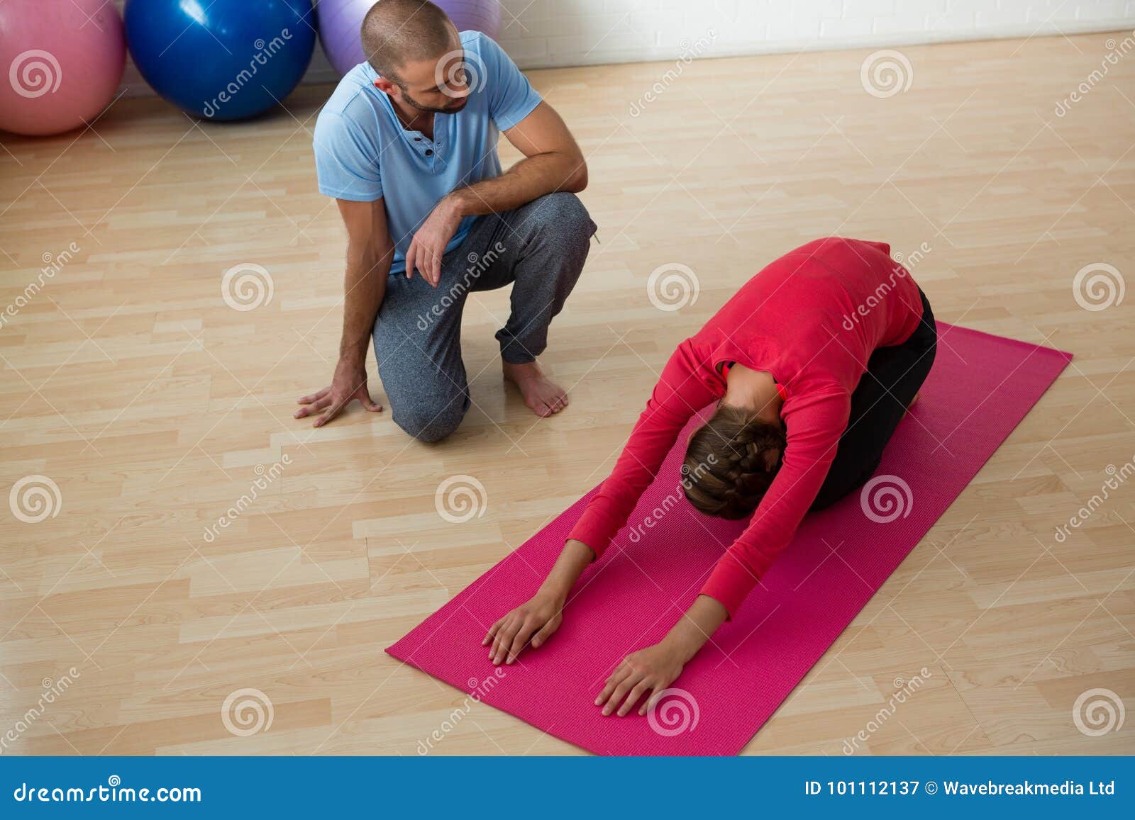 Instructor Guiding Student in Doing Child Pose at Yoga Studio Stock ...