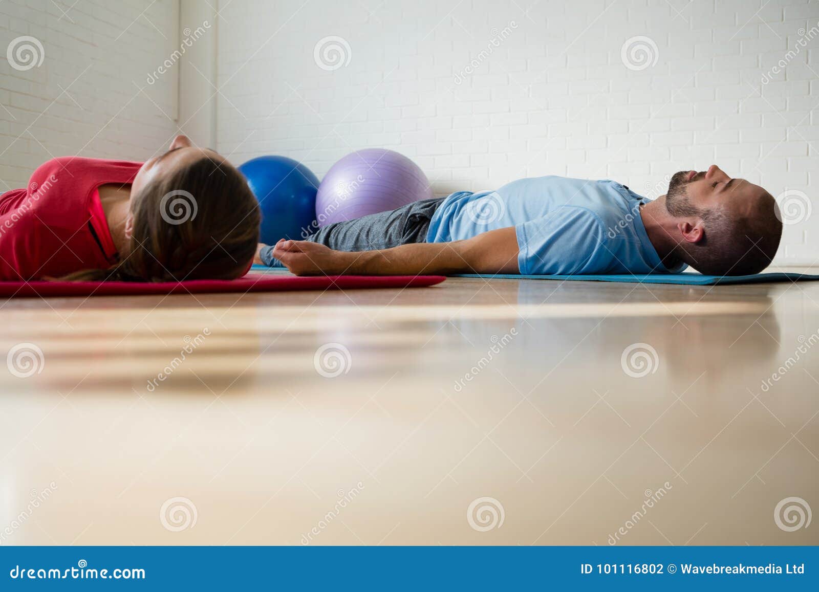 Instructor and Student Exercising while Lying on Mat in Studio Stock ...