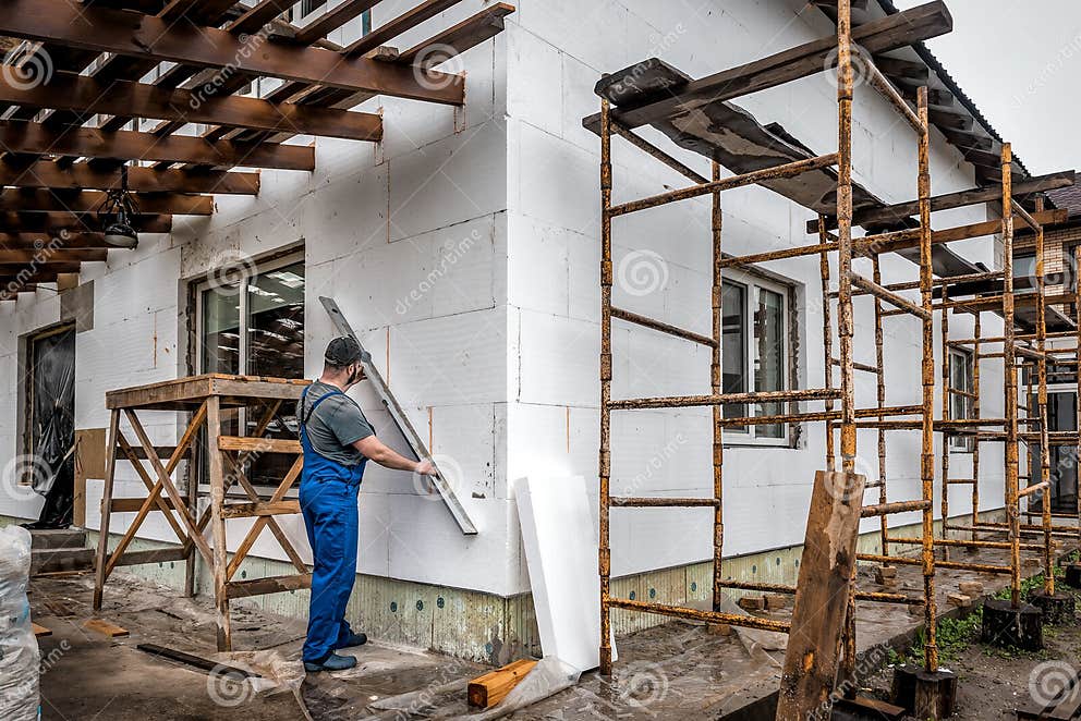 Insulation of the House with Polyfoam. the Worker is Checking with the ...