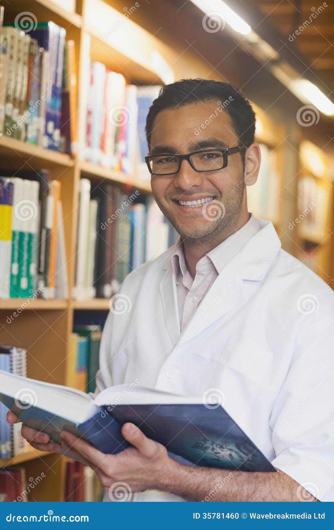 Intellectual Handsome Man Posing Holding an Opened Book in Library ...