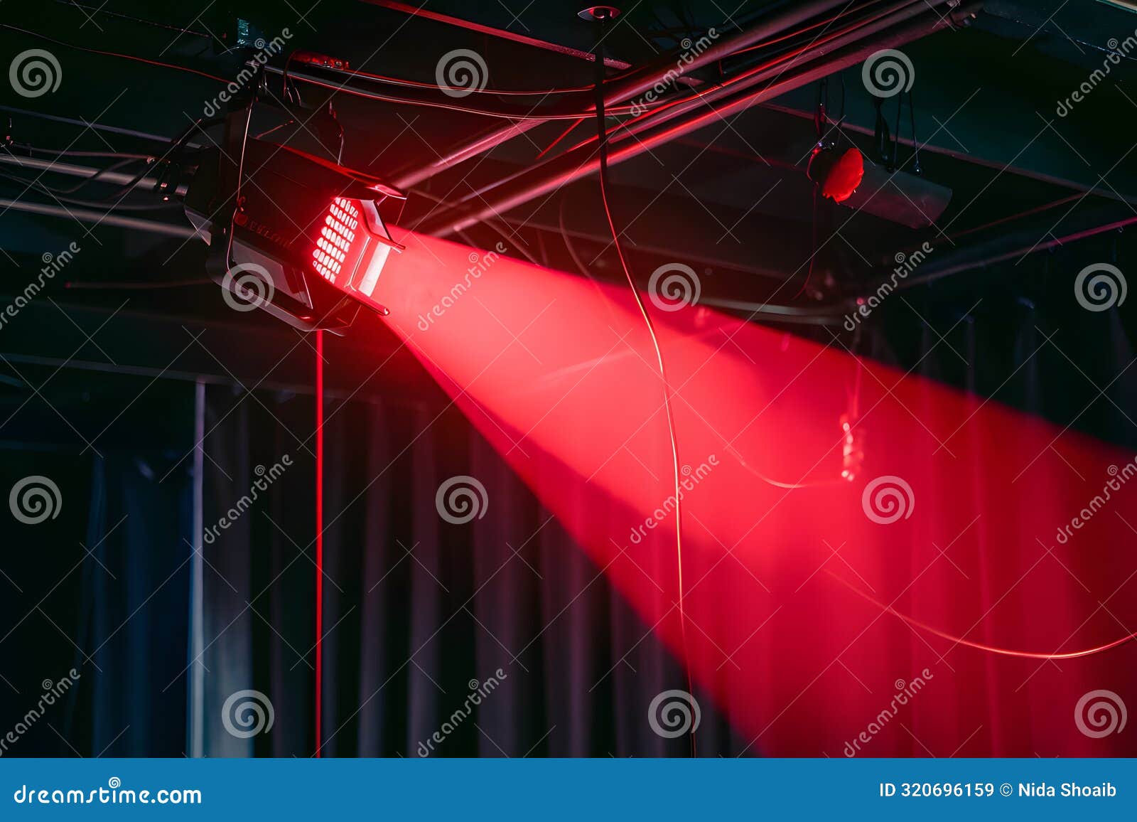 Intense Red Spotlight on Stage in Dimly Lit Theater with Visible Cables ...