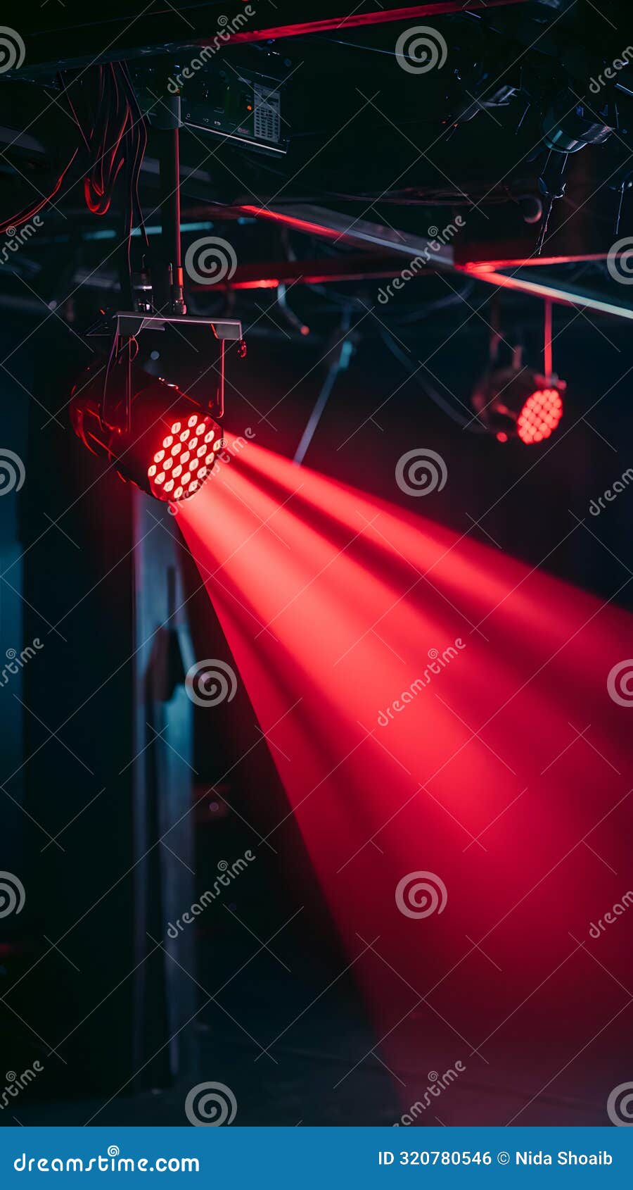 Intense Red Spotlight on Stage in Dimly Lit Theater with Visible Cables ...