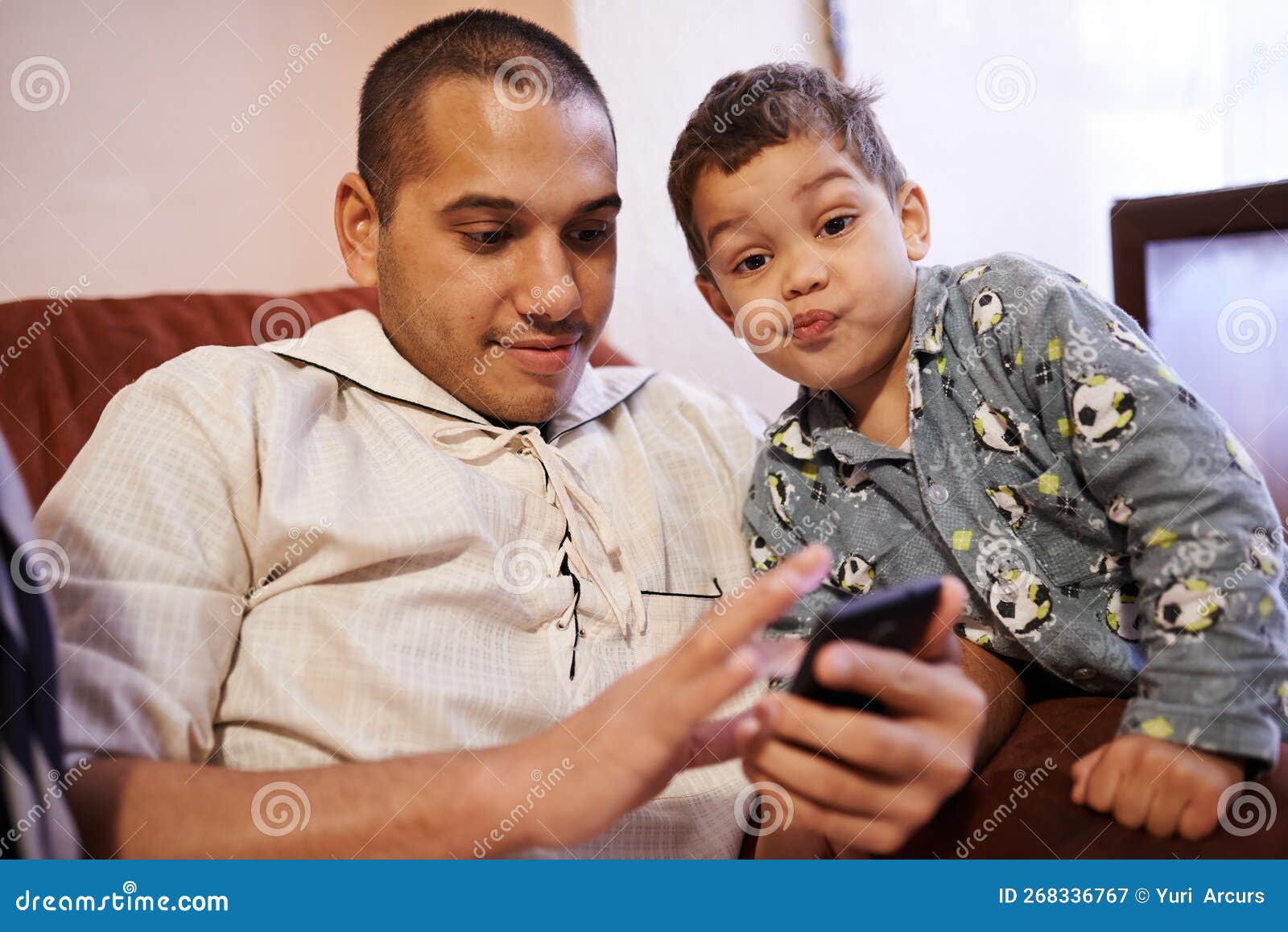So Interested in Everything Dad Does. a Father Sitting on the Sofa with ...