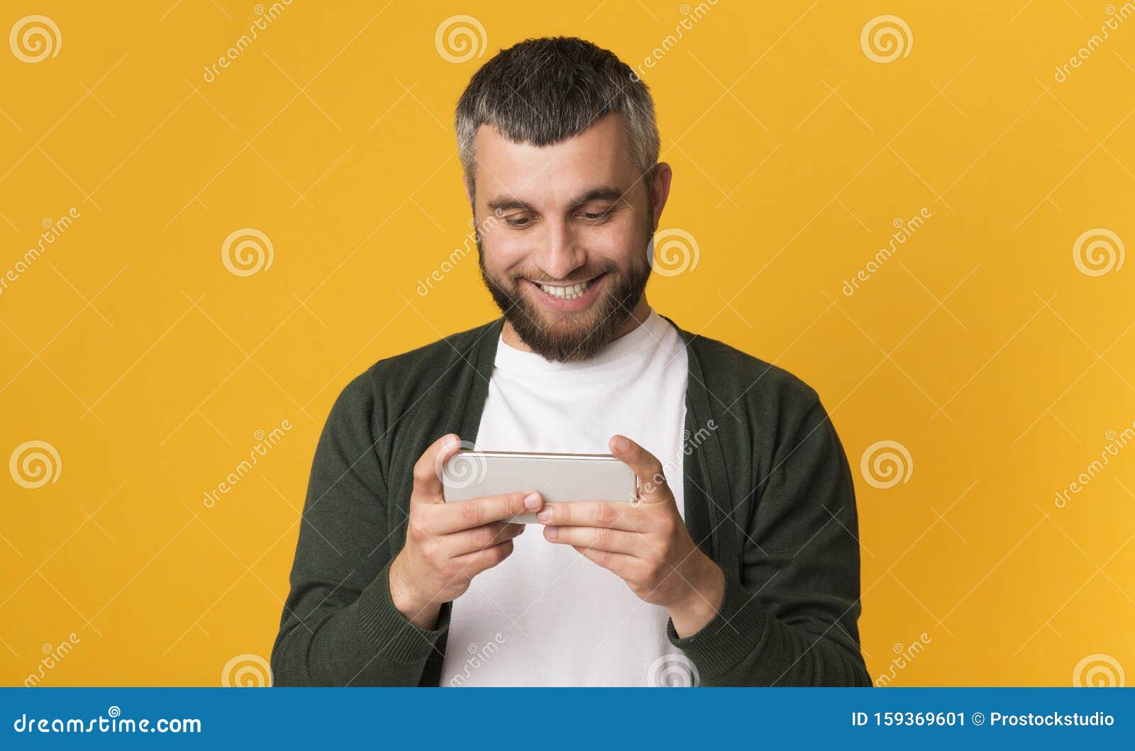 Interested Happy Man Using Smartphone on Yellow Background Stock Image ...