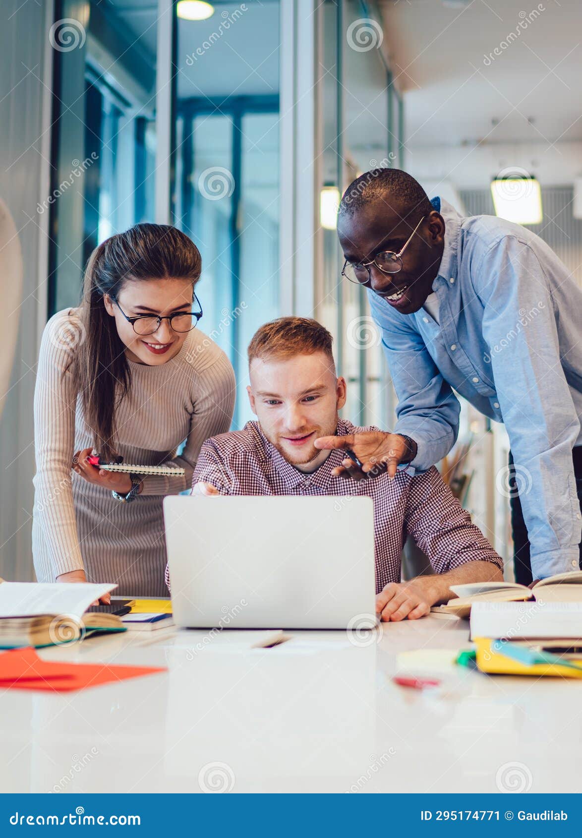 Interested Multiracial Students Doing Research and Browsing Laptop in ...