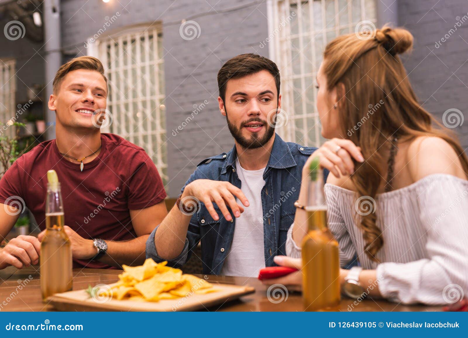 Three Young People Talking and Eating in the Bar Stock Image - Image of ...