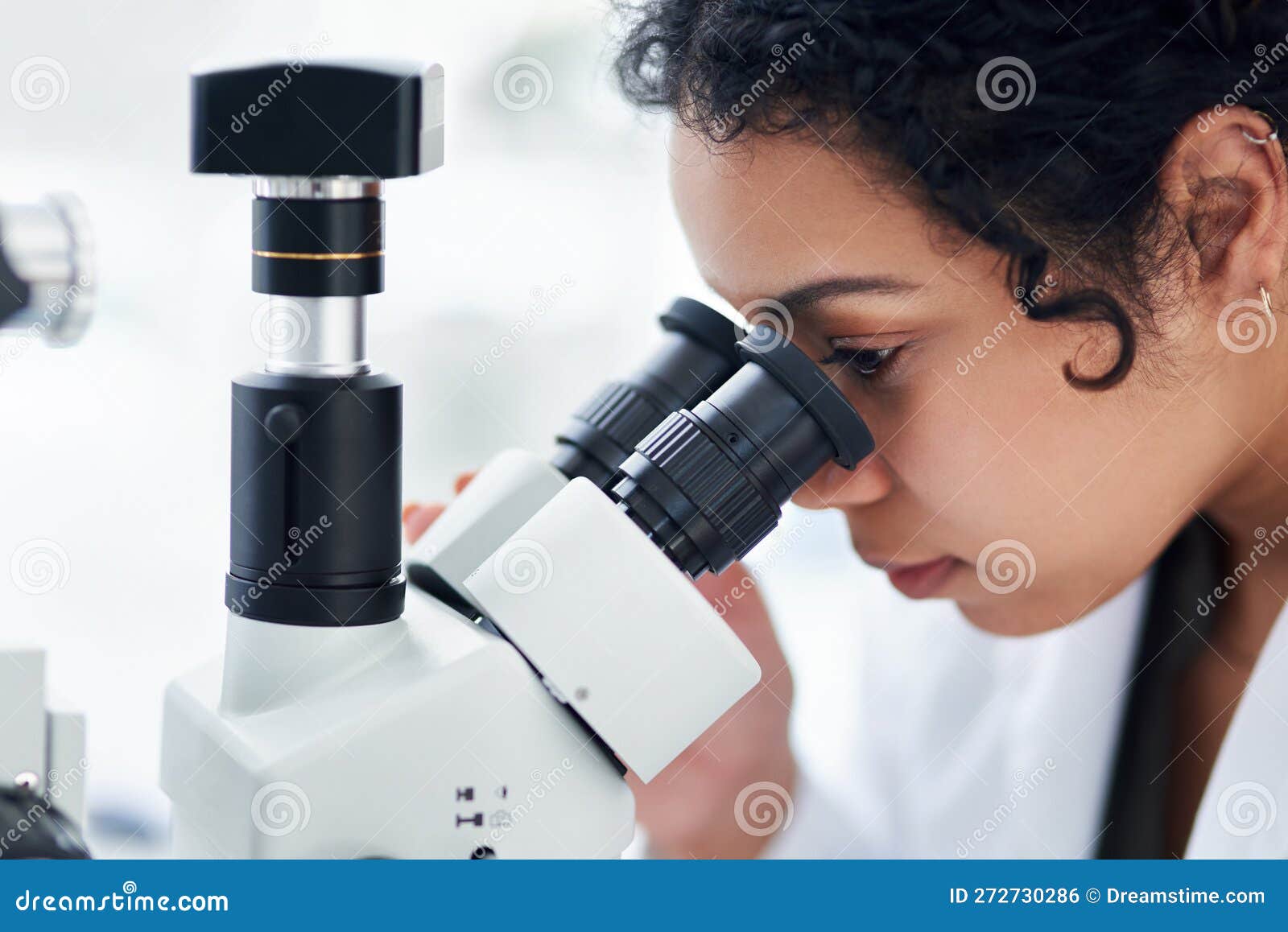 This is Interesting. a Young Female Scientist Using a Microscope in a ...
