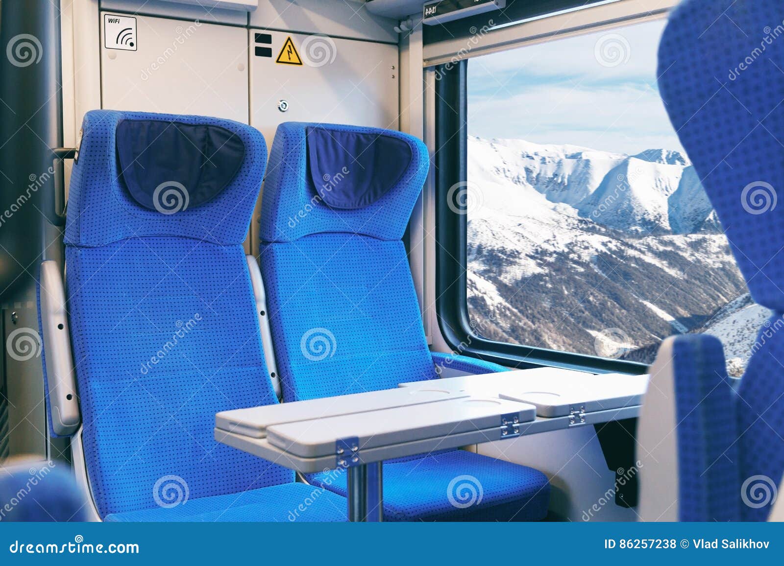 Interior of an Empty Passenger Train with Blue Chairs and Mountain ...