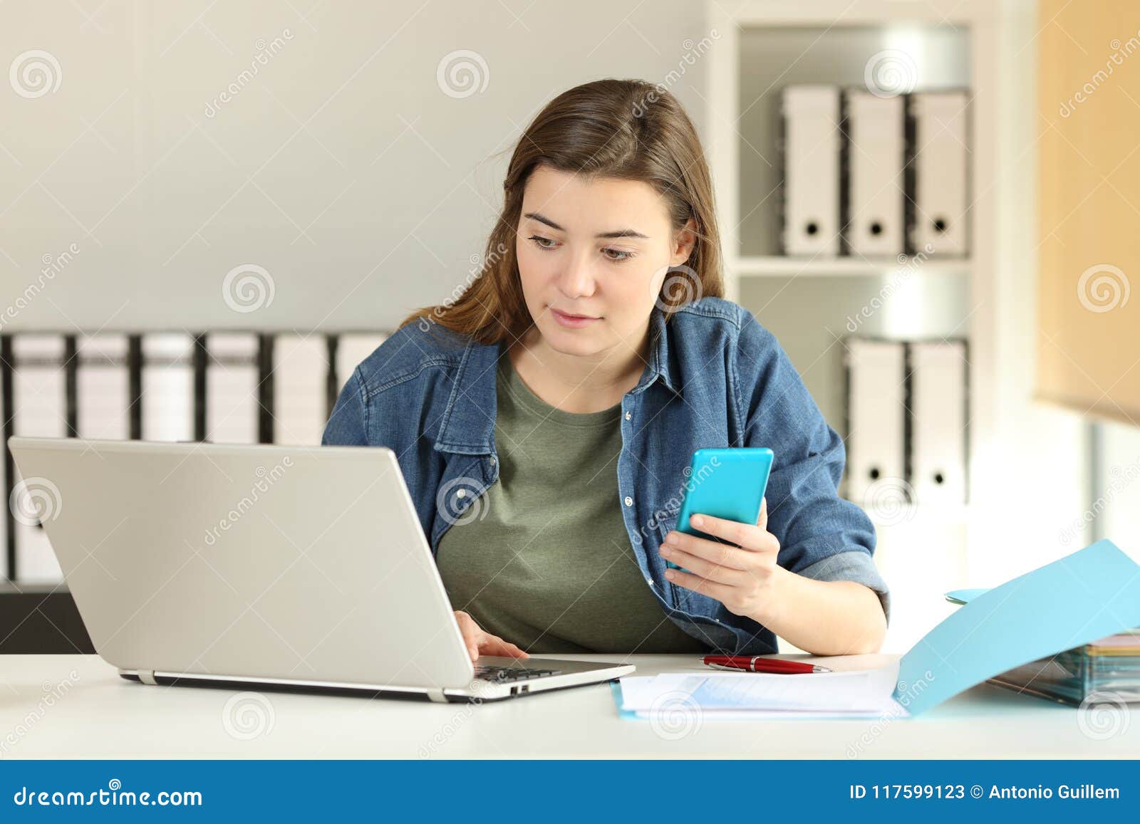 Intern Working with a Phone and a Laptop Stock Image - Image of ...