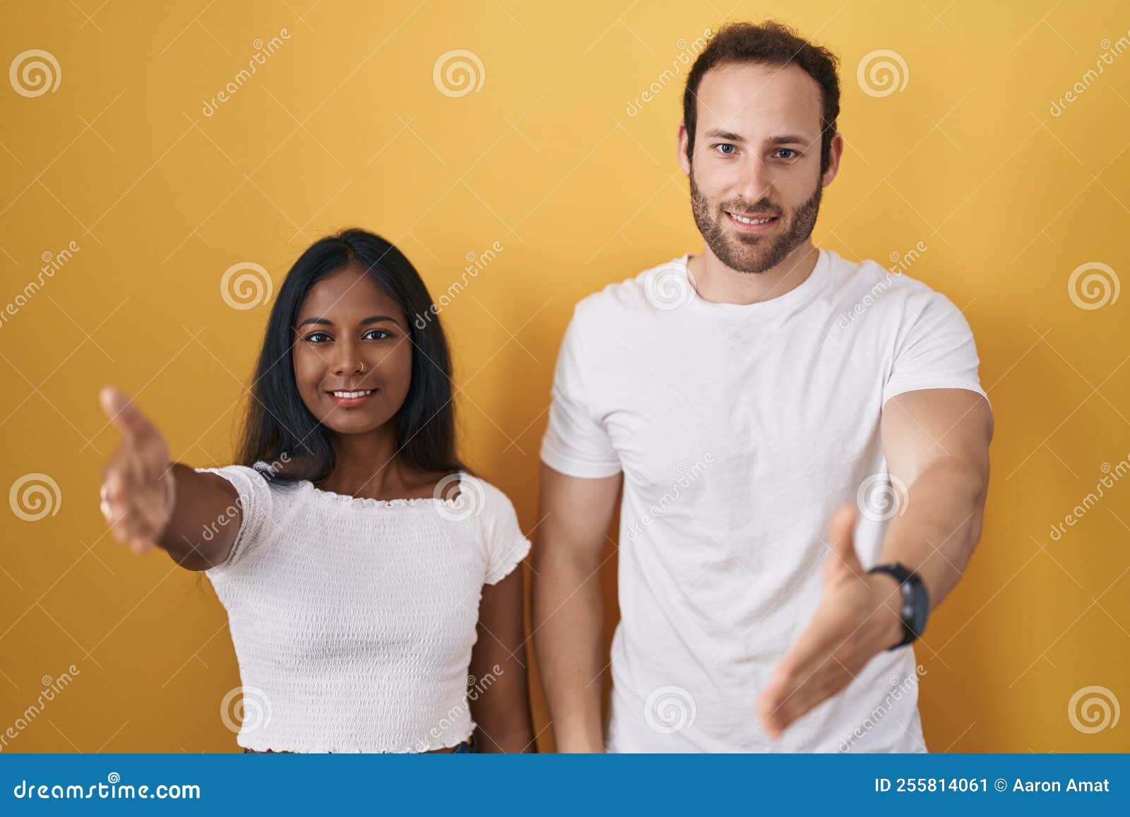 Interracial Couple Standing Over Yellow Background Smiling Friendly