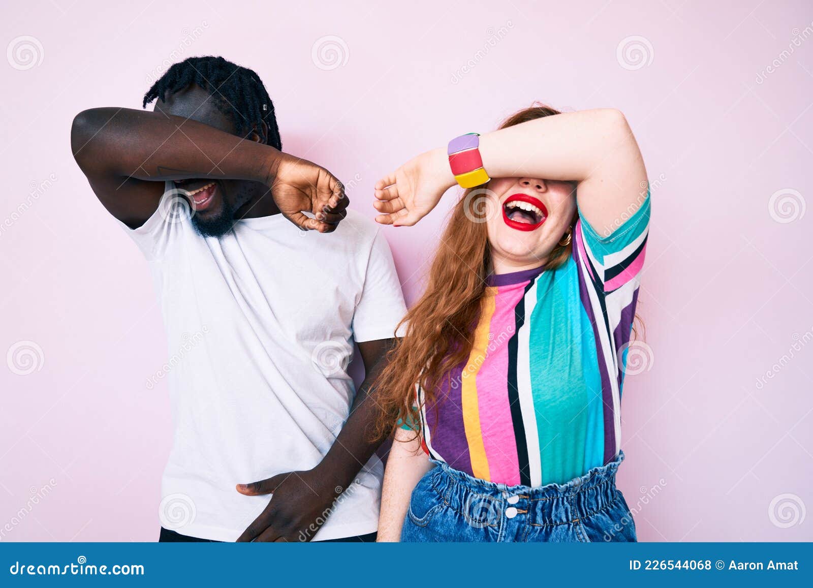 Interracial Couple Wearing Casual Clothes Covering Eyes With Arm