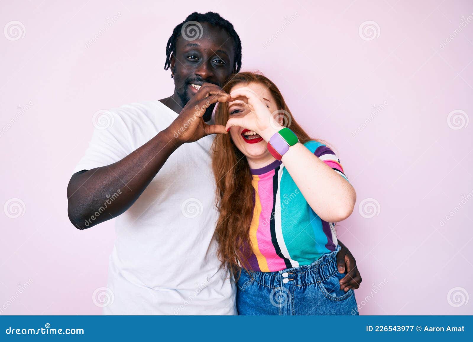Interracial Couple Wearing Casual Clothes Doing Heart Shape With Hand