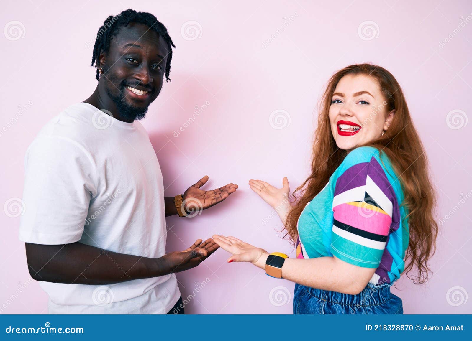 Interracial Couple Wearing Casual Clothes Inviting To Enter Smiling
