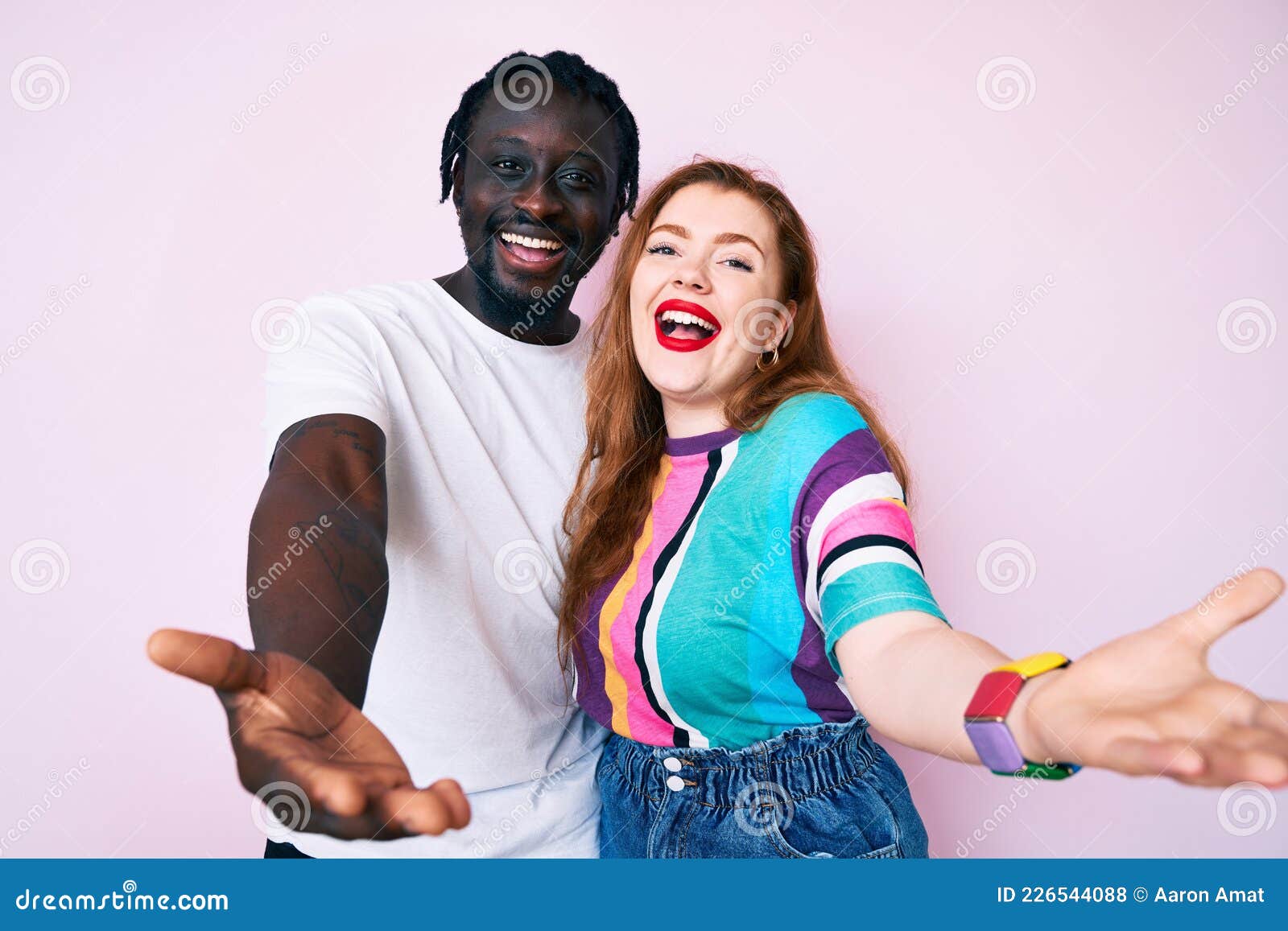 Interracial Couple Wearing Casual Clothes Smiling Cheerful Offering