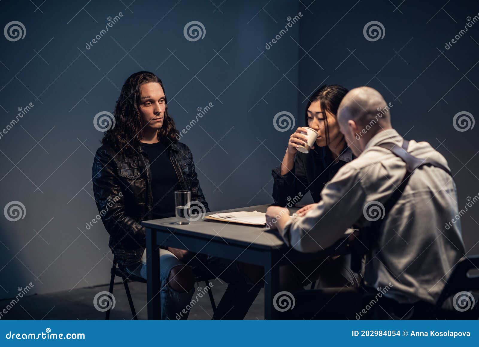 In the Interrogation Room, the Investigator Shows the Suspect Evidence ...