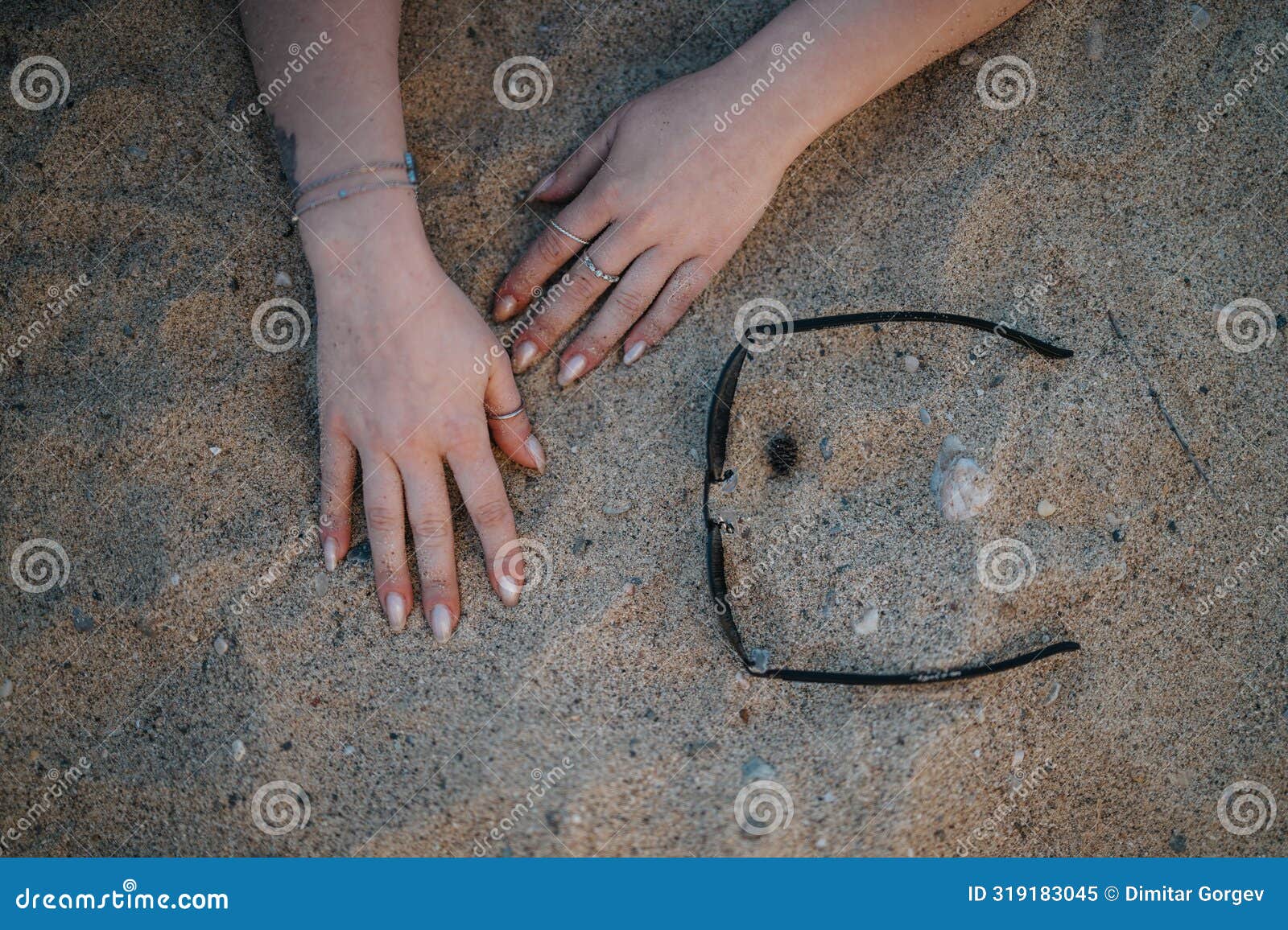 Close-up of Hands Touching Gently on Sandy Beach with Partial Smiley ...