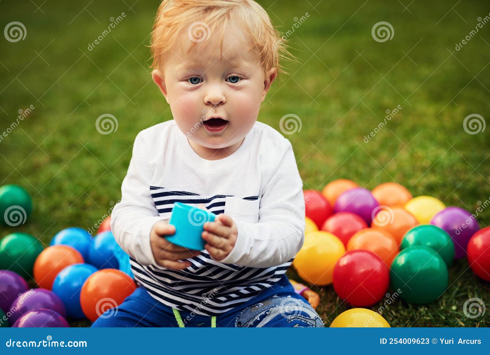 Intrigued by the Colour. an Adorable Little Boy Playing in the Backyard ...