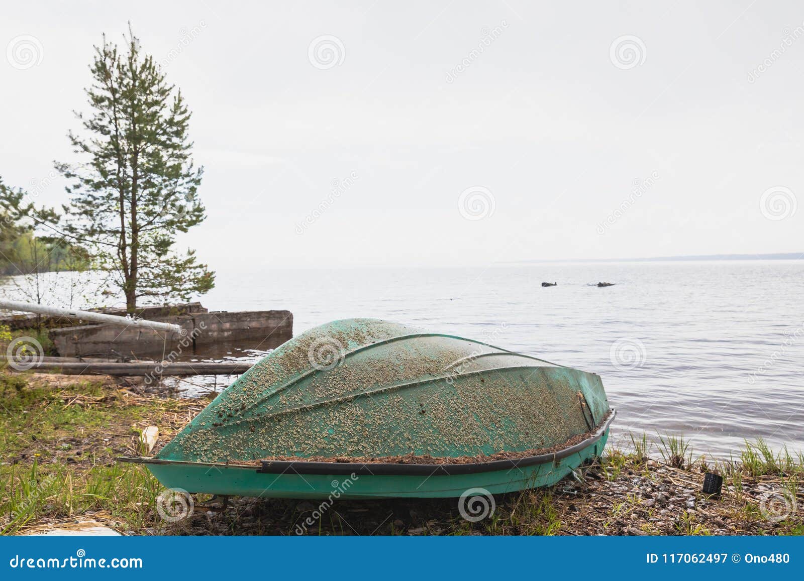The Old Inverted Green Color Boat Lies On The Sea Shore In Cloudy Day ...