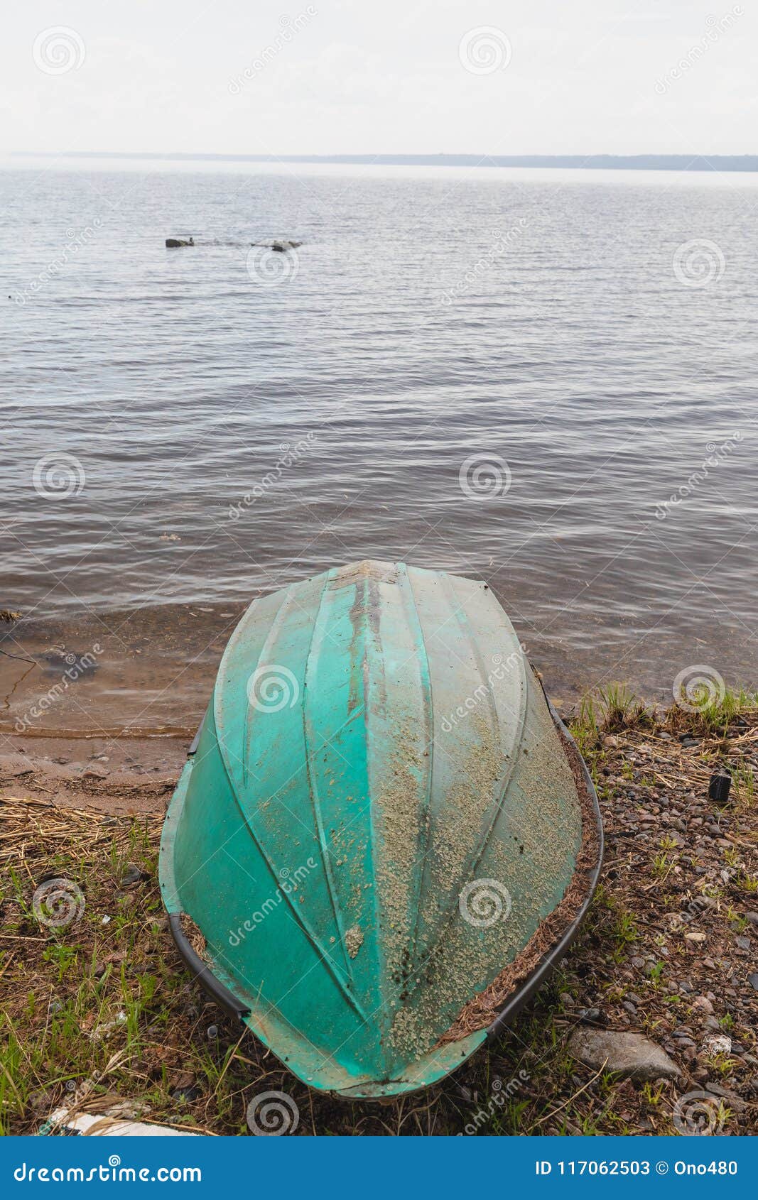 The Old Inverted Green Color Boat Lies On The Sea Shore In Cloudy Day ...