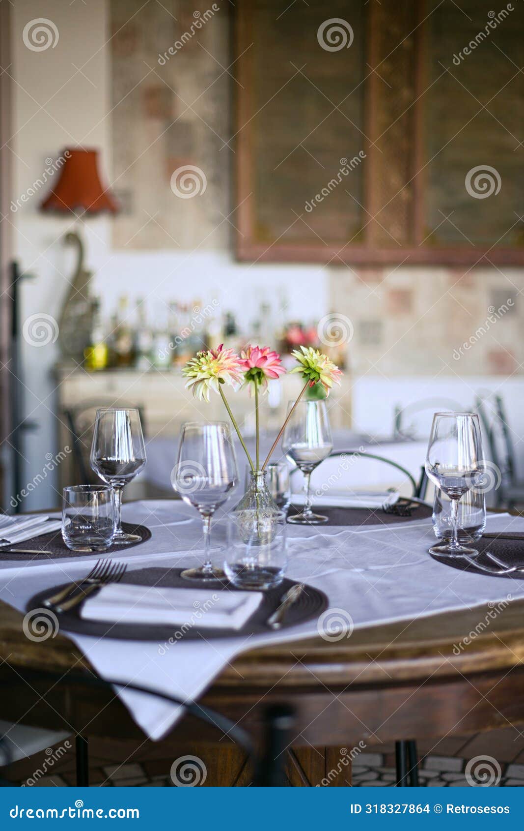 Charming Restaurant Table Set for Dinner with Flowers and Wine Glasses ...