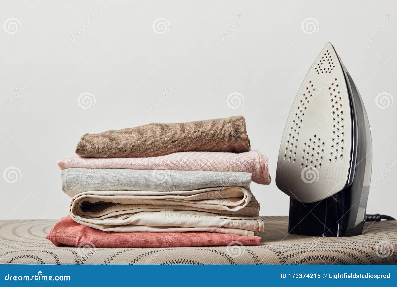 Iron and Folded Ironed Clothes on Stock Image - Image of heap ...