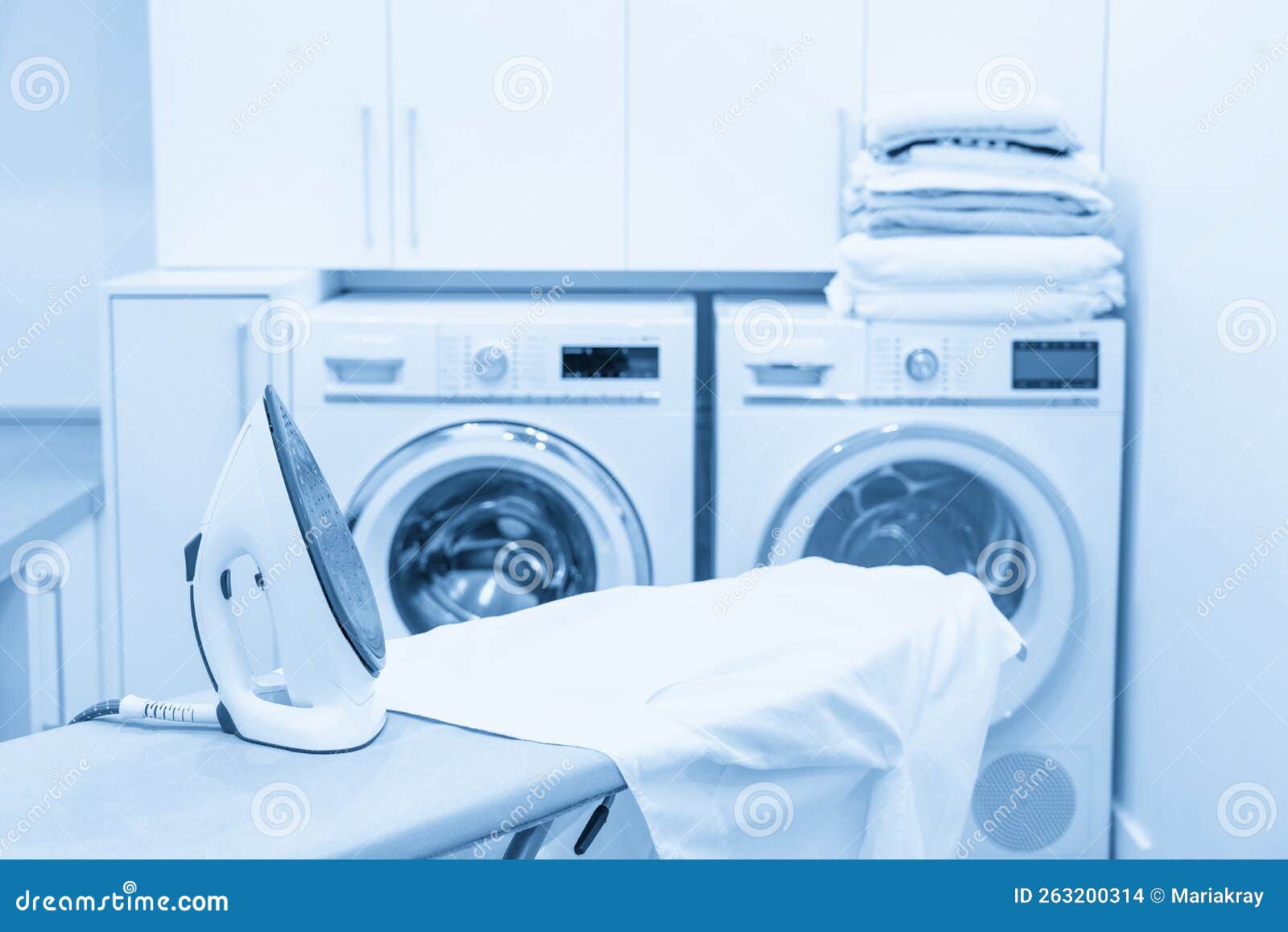 Iron on Ironing Board with White Shirt in Laundry Room Stock Photo ...