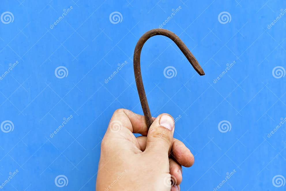 Iron Rusty Hook in Hand on a Blue Background Stock Photo - Image of ...