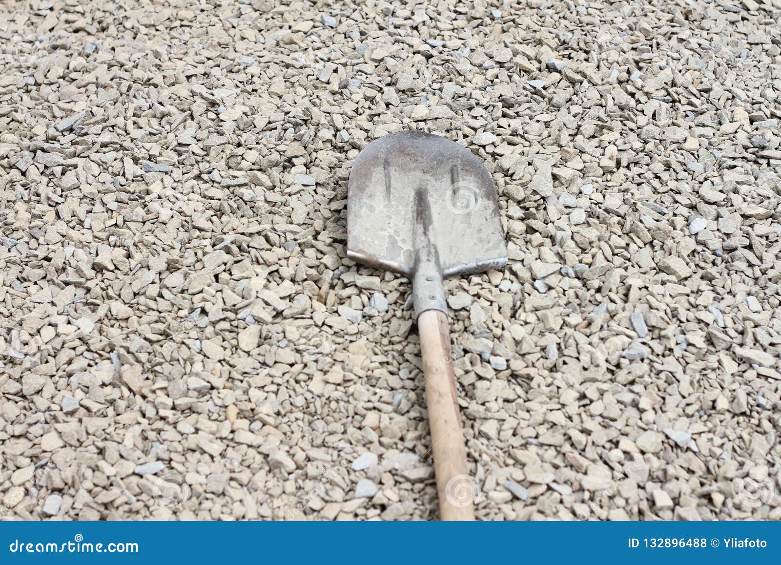 An Iron Shovel And A Black Plastic Bucket Stand On The Gravel Next To A ...