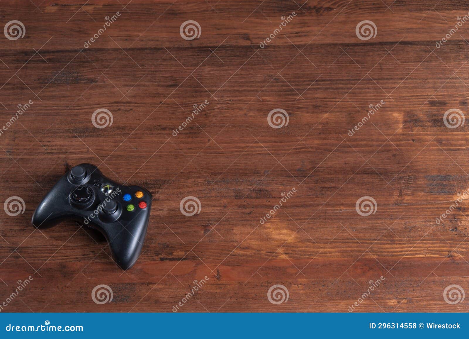 There is a Gaming Controller on the Table by Himself and he is Next To ...