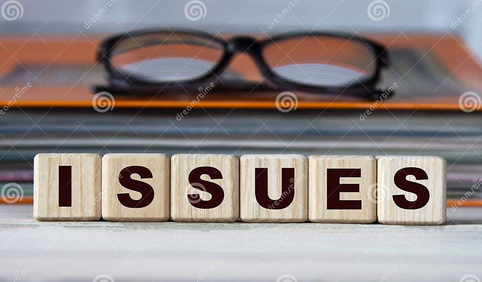 ISSUES - Word on Wooden Cubes on the Background of a Folder with ...
