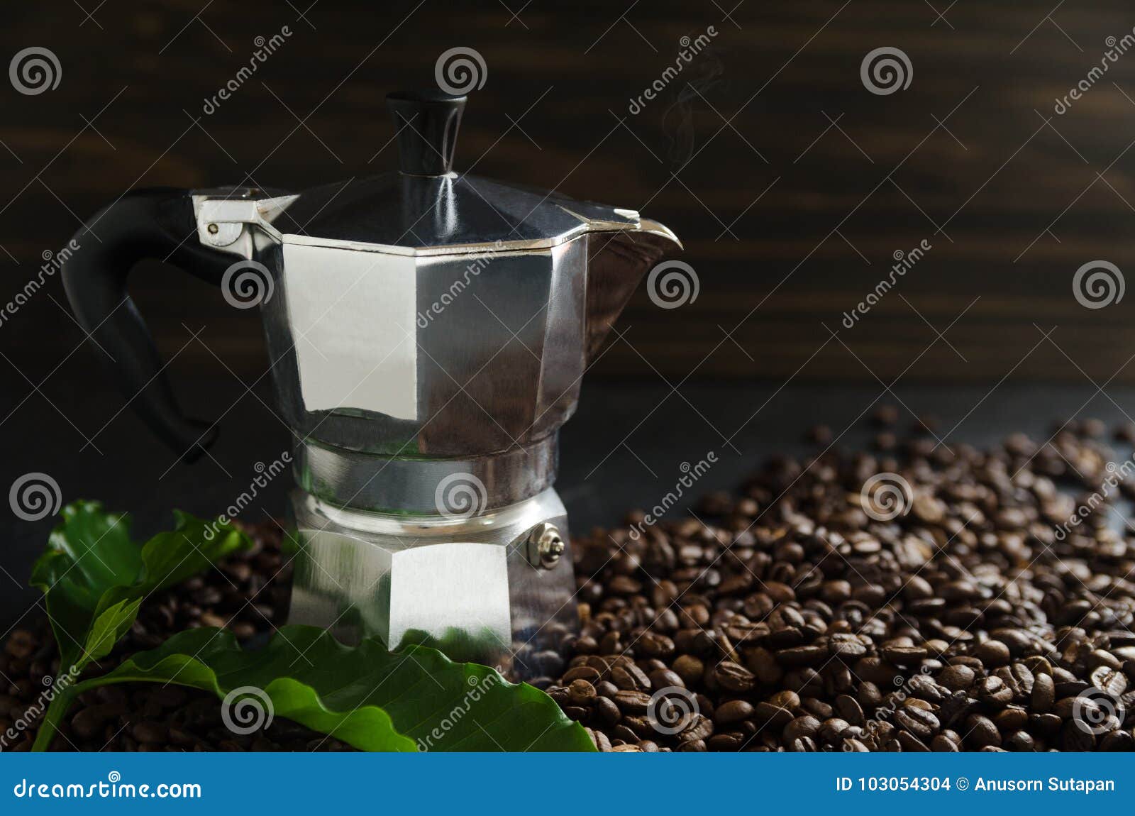 Italian Coffee Maker and Coffee Beans with Leaves on Brown Background ...