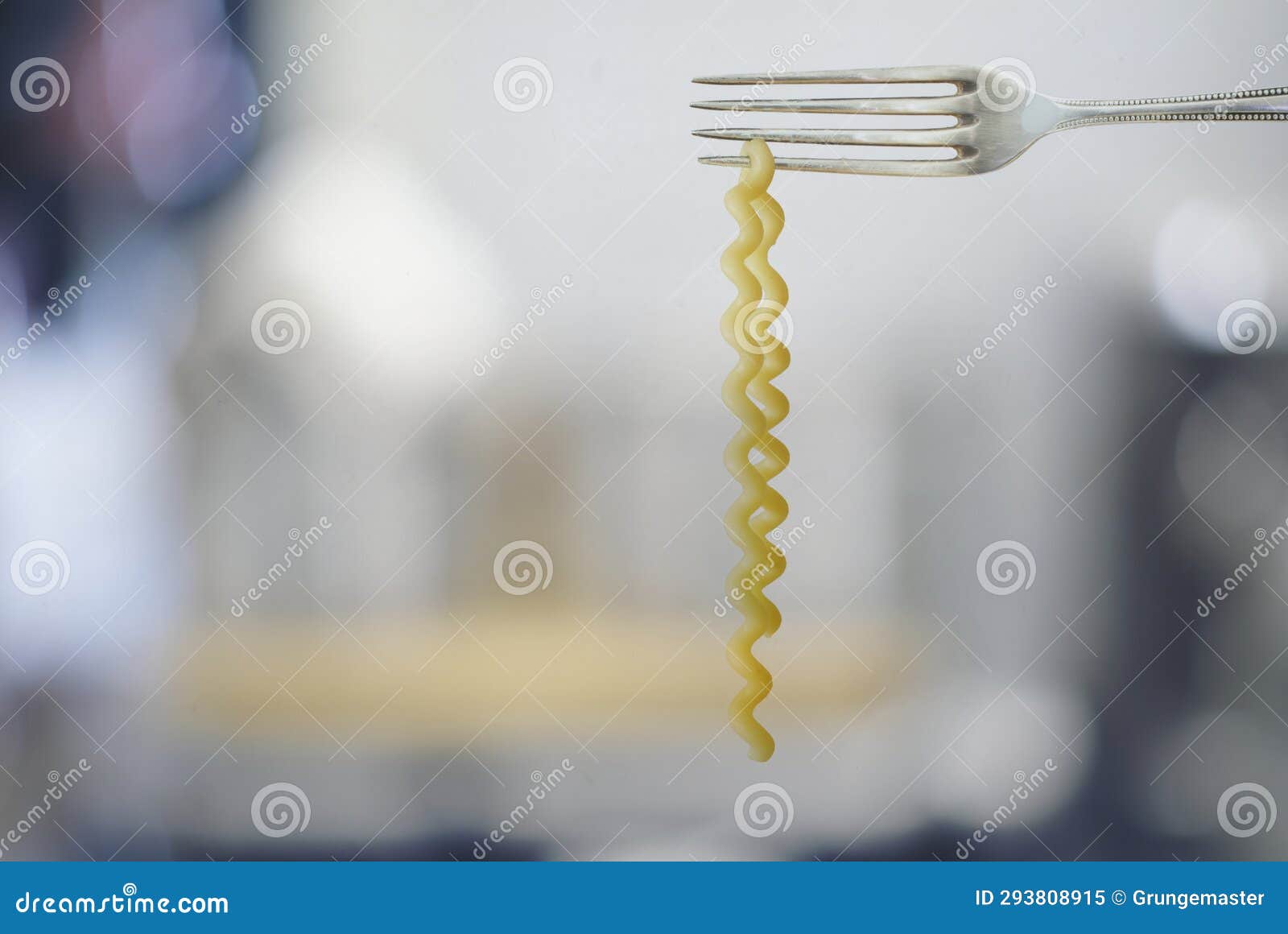 Italian Pasta Hanging from a Silver Fork, Isolated on Blurred Kitchen ...