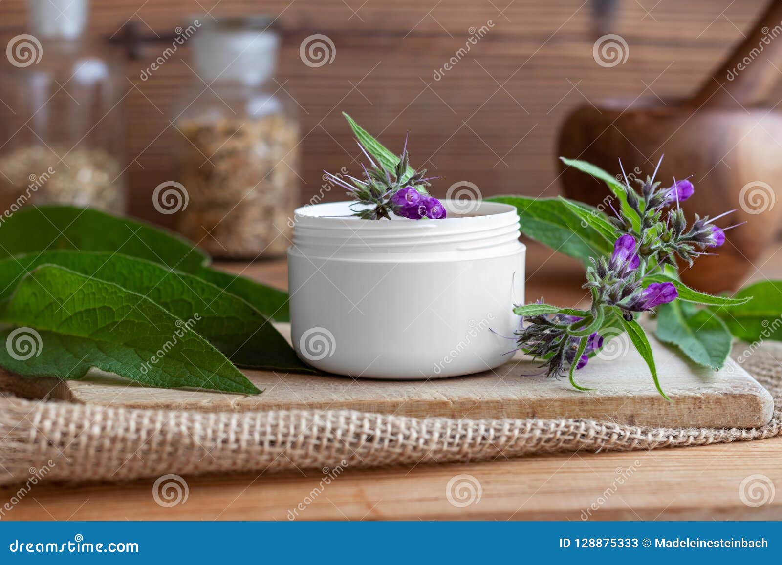 A Jar of Homemade Comfrey Root Ointment with Fresh Blooming Comfrey ...