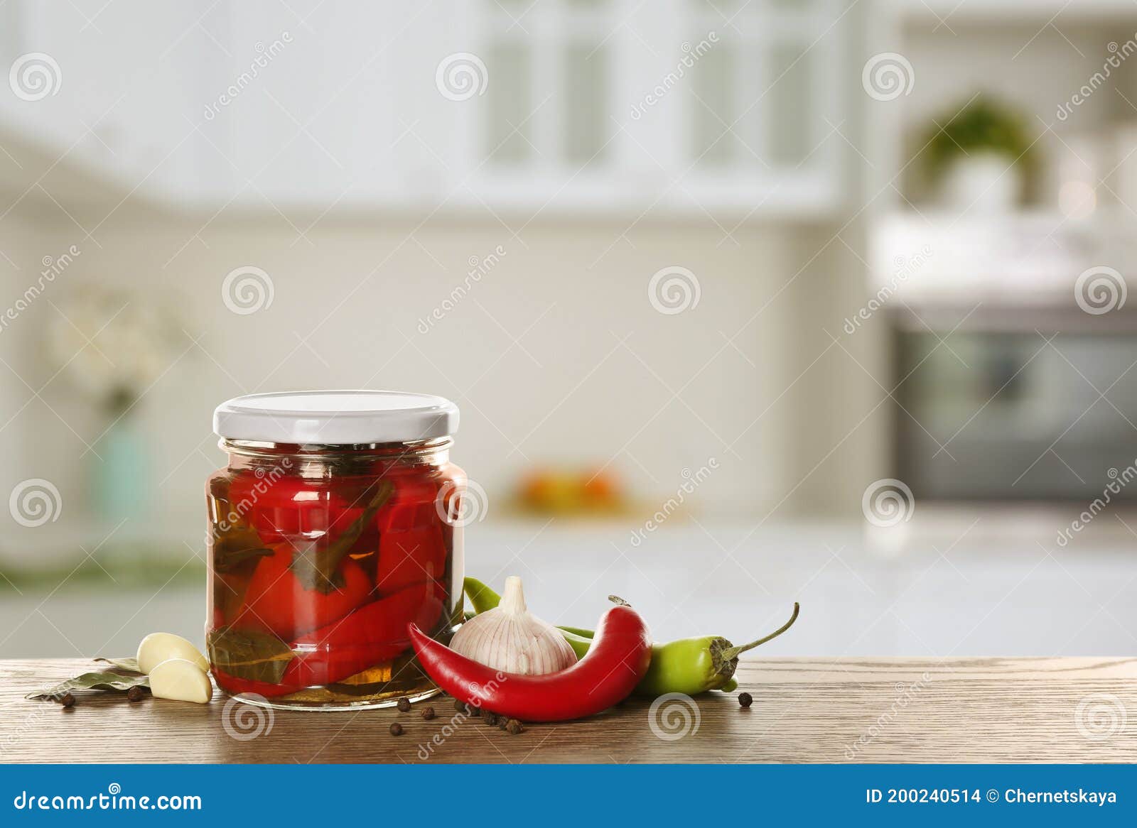 Jar with Pickled Chili Peppers on Wooden Table in Kitchen. Space for ...