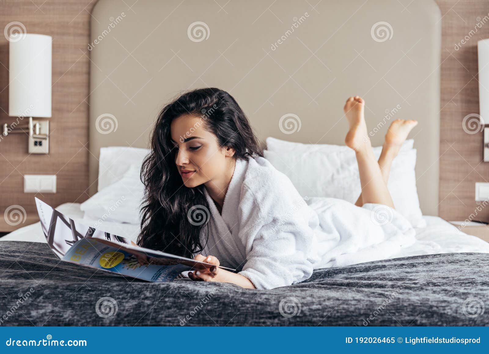 Jeune Femme Aux Pieds Nus Brune Dans Le Peignoir Blanc Couché Sur Le