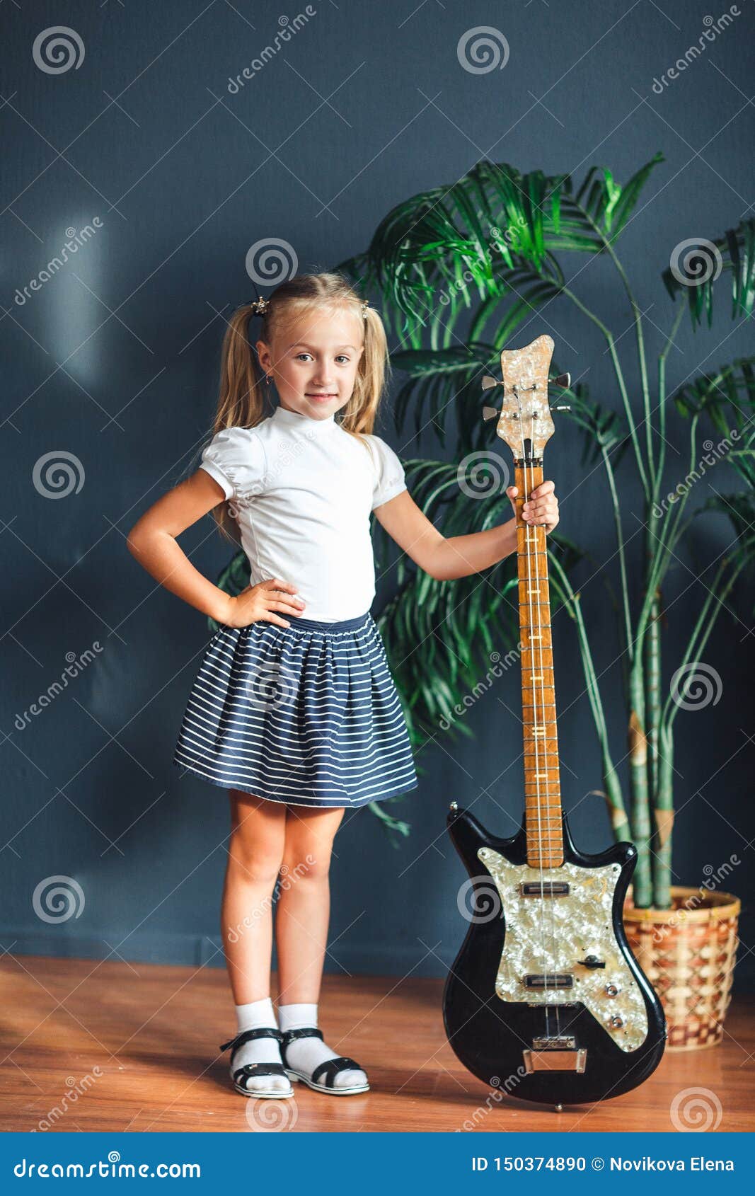 Jeune Fille Blonde Avec Des Queues En T Shirt Jupe Et Sandales Blancs