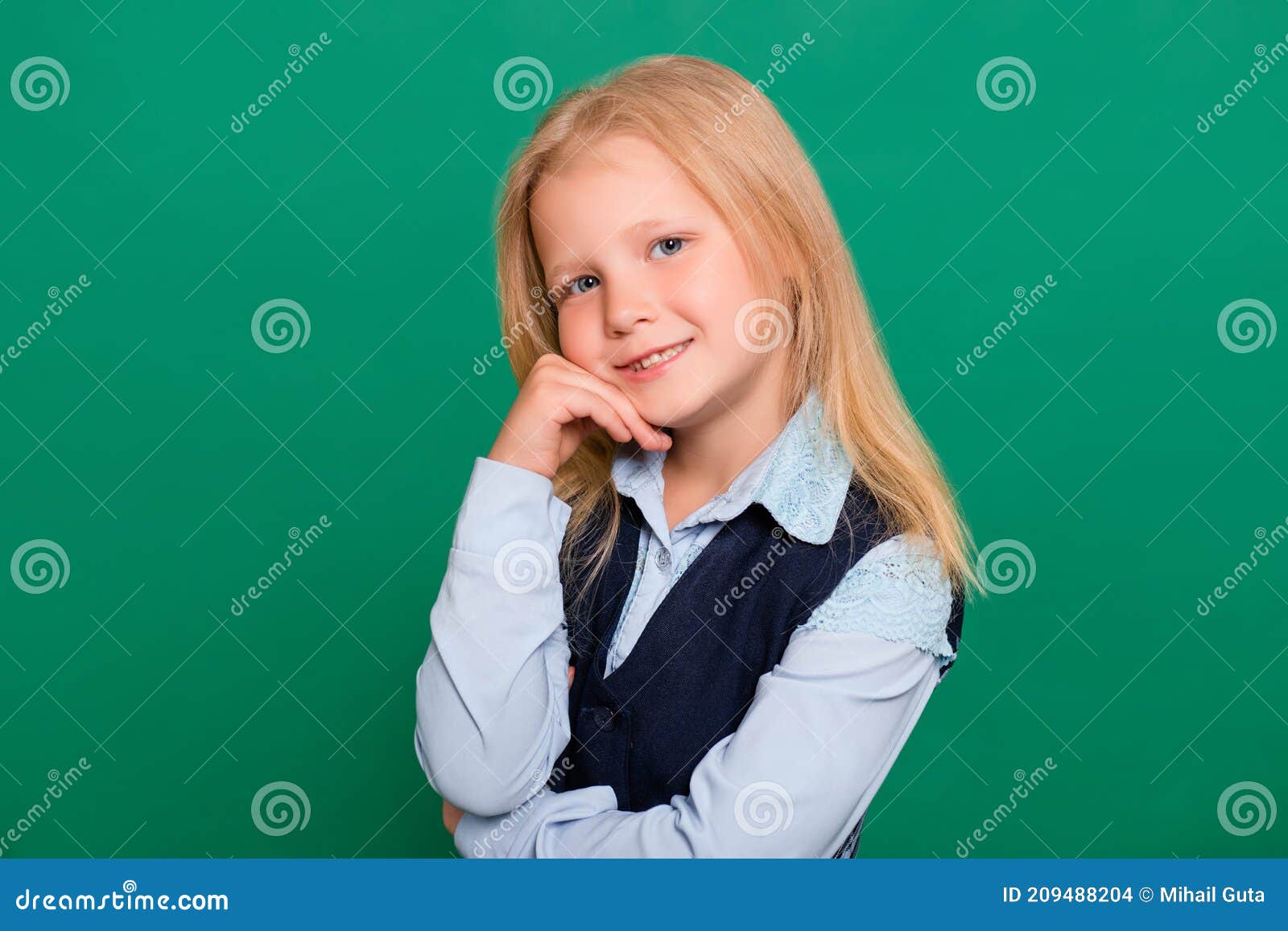 Jeune Fille En Uniforme Scolaire Posant Sur Un Fond Vert Photo Stock