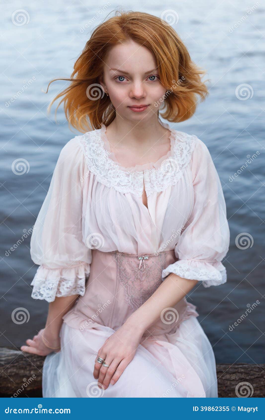 Jeune Fille En Robe Redhaired Rose Sur Le Fond De La Mer Image Stock