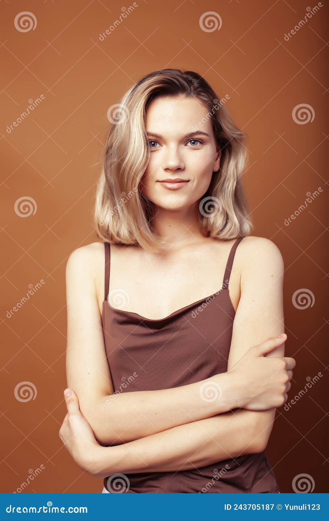 Jeune Jolie Fille Aux Cheveux Blonds Posant Gai Sur Fond Brun Mode De