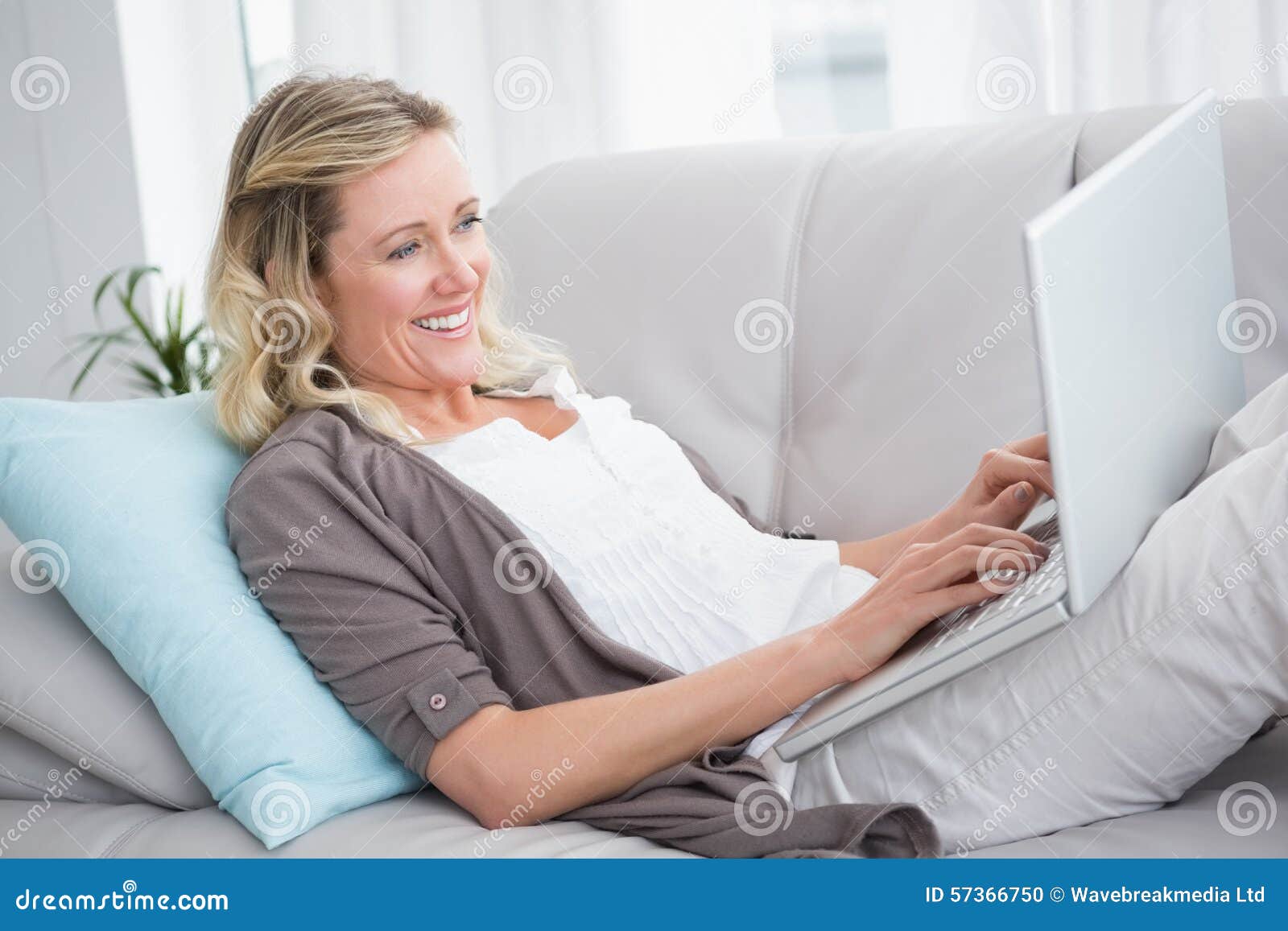 Jolie Femme Se Trouvant Sur Le Sofa Utilisant Son Ordinateur Portable Photo Stock Image Du