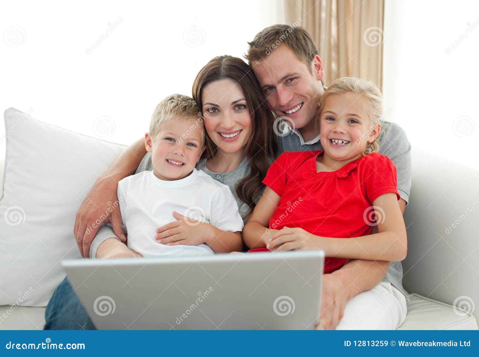 Jolly Family Using a Computer Sitting on Sofa Stock Image - Image of ...
