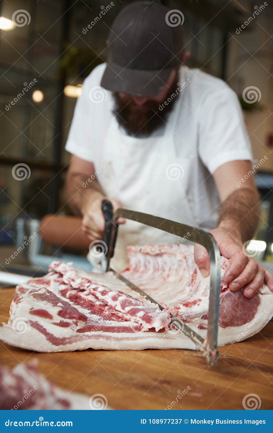 Jong Slagers Zagend Vlees Bij Een Verticale Slagerij, Stock Afbeelding ...